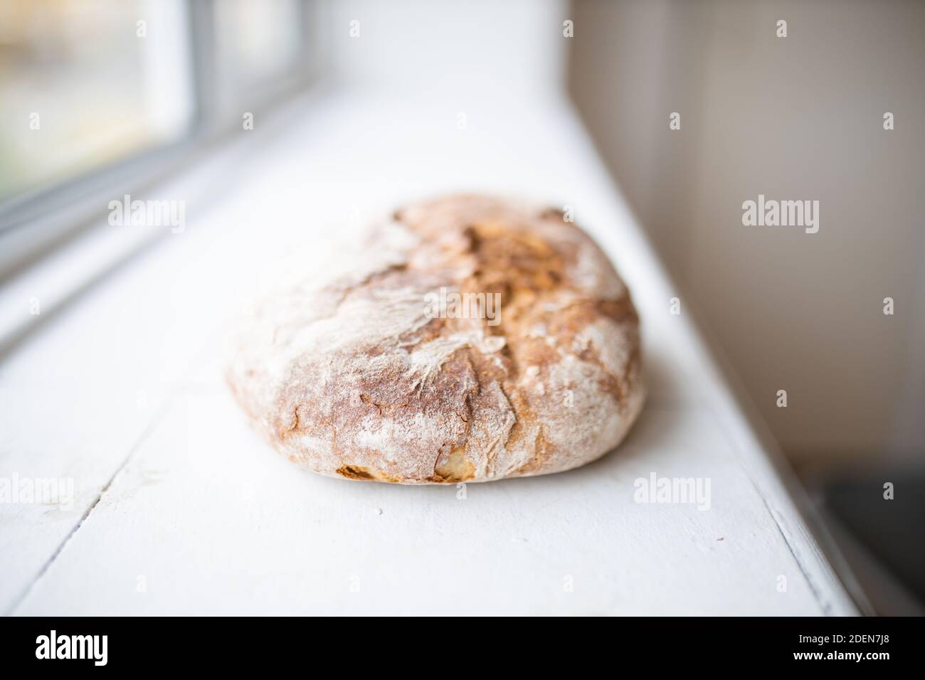 Sourdough bread on a white kitchen counter next to a window Stock Photo ...