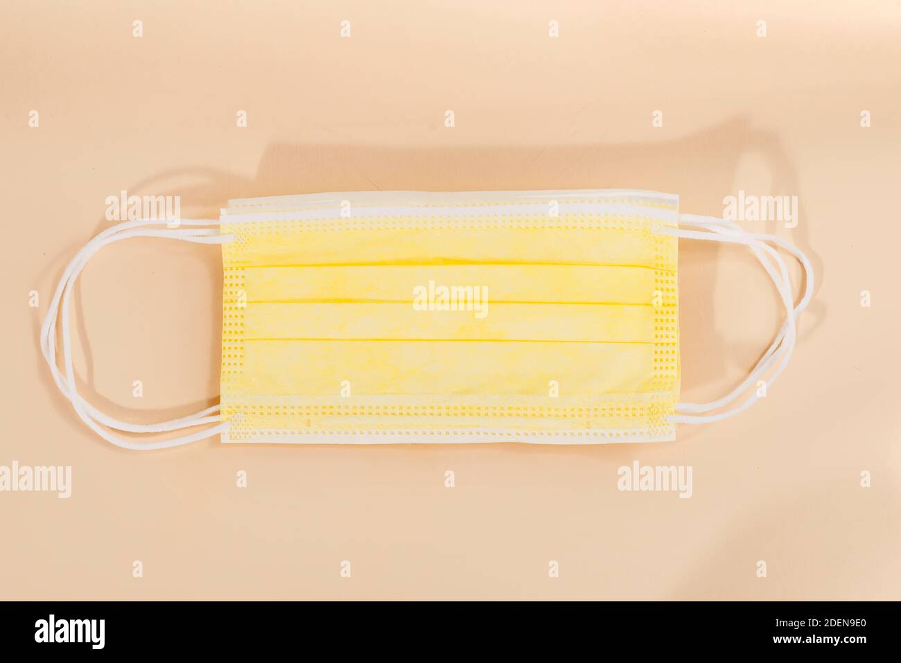 Top view of yellow surgical face protection mask isolated on beige ...