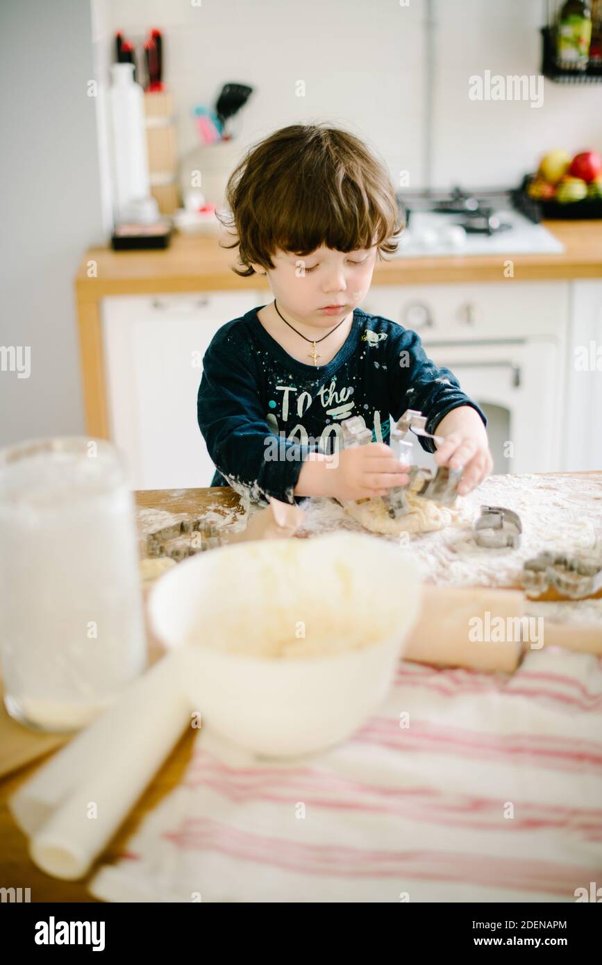 Little boy in the kitchen helping to cook the dough for baking Stock ...