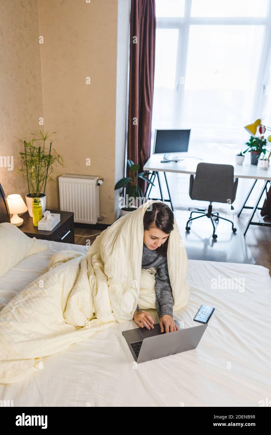 woman working in bed on laptop covered with blanket copy space Stock ...