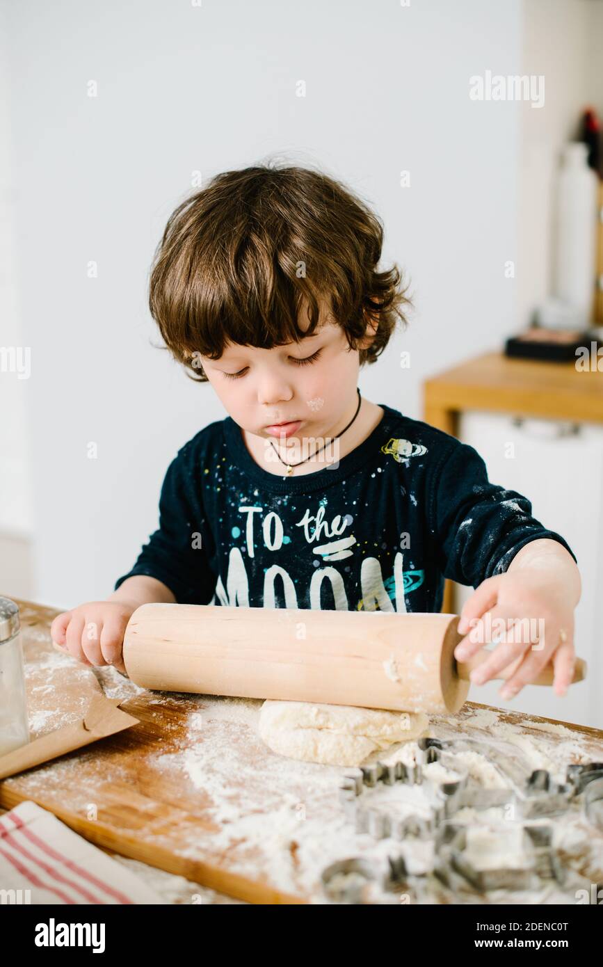 Little boy in the kitchen helping to cook the dough for baking Stock ...