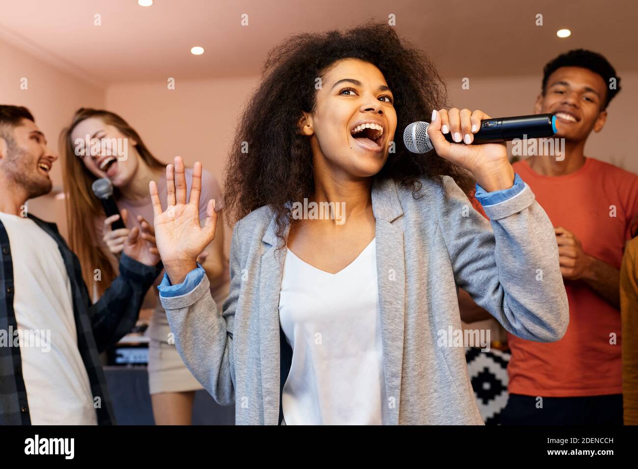 Sing on. Pretty mixed race girl looking happy while holding microphone ...