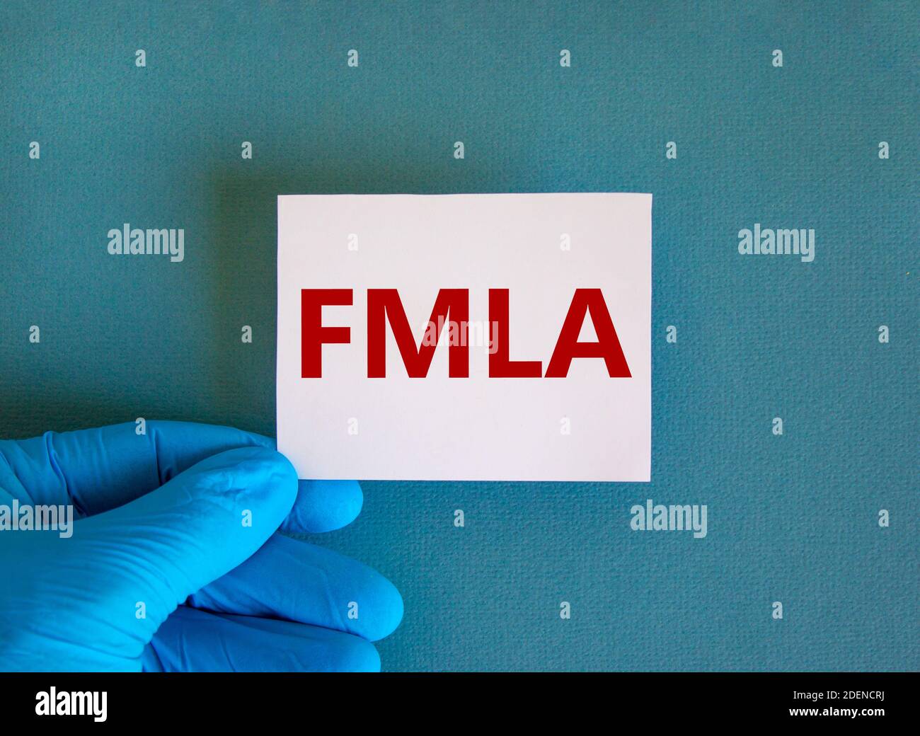 FMLA symbol. Hand in blue glove with white card. Concept words 'FMLA ...