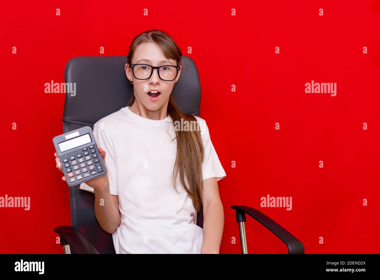 Young surprised caucasian girl counting calculator. Education concept ...