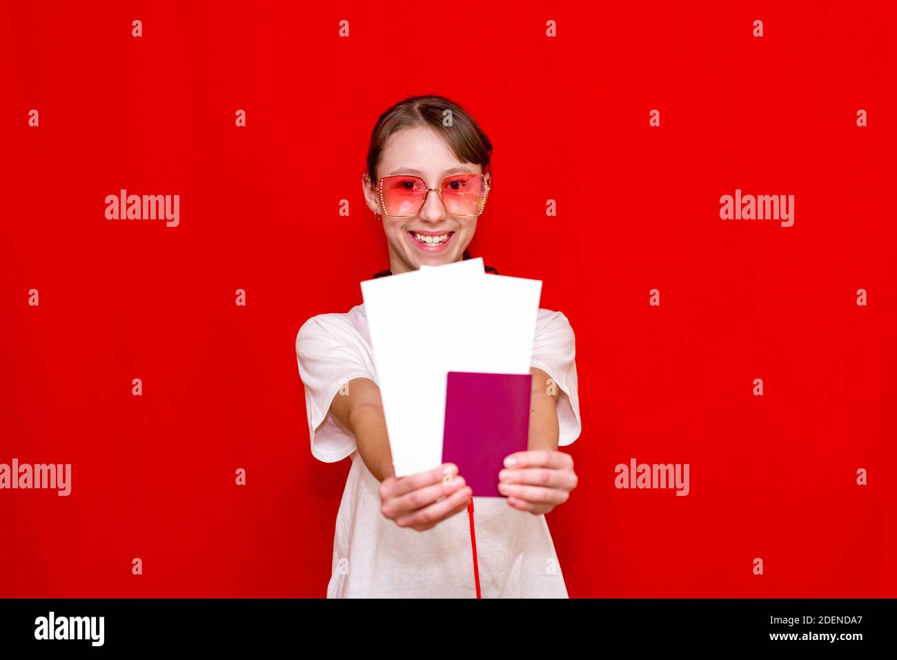 Beautiful teen Girl With Passport And Flight Tickets, on red studio ...