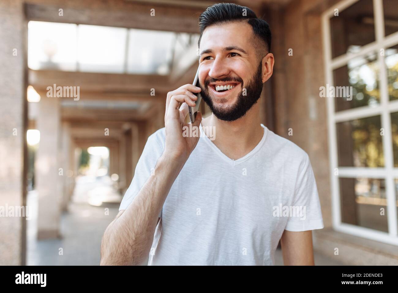 Portrait of a beautiful stylish Guy talking on the phone, on the ...