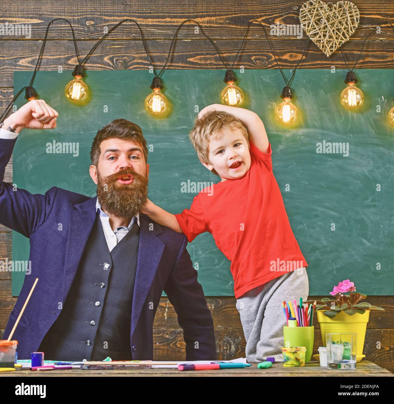 Cool daddy and kid showing muscles. Man and boy shouting or singing ...