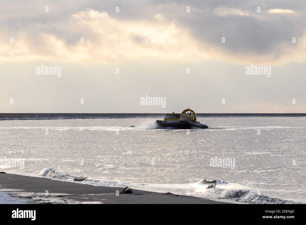 Hovercraft flying above water. Air cushion sailing near beach. Yellow ...