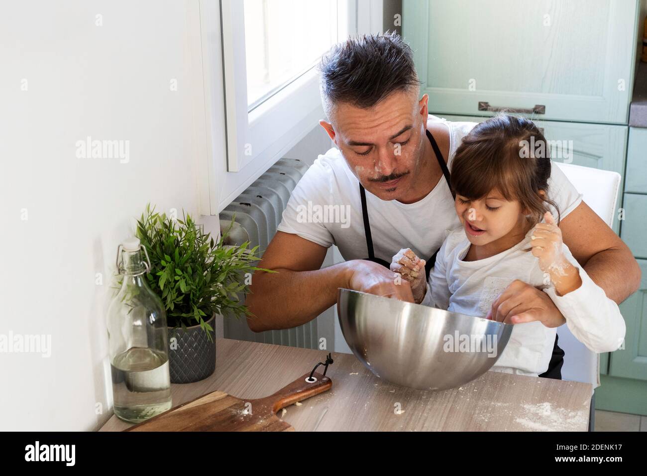Caring dad and cute little preschooler daughter cooking in the kitchen ...