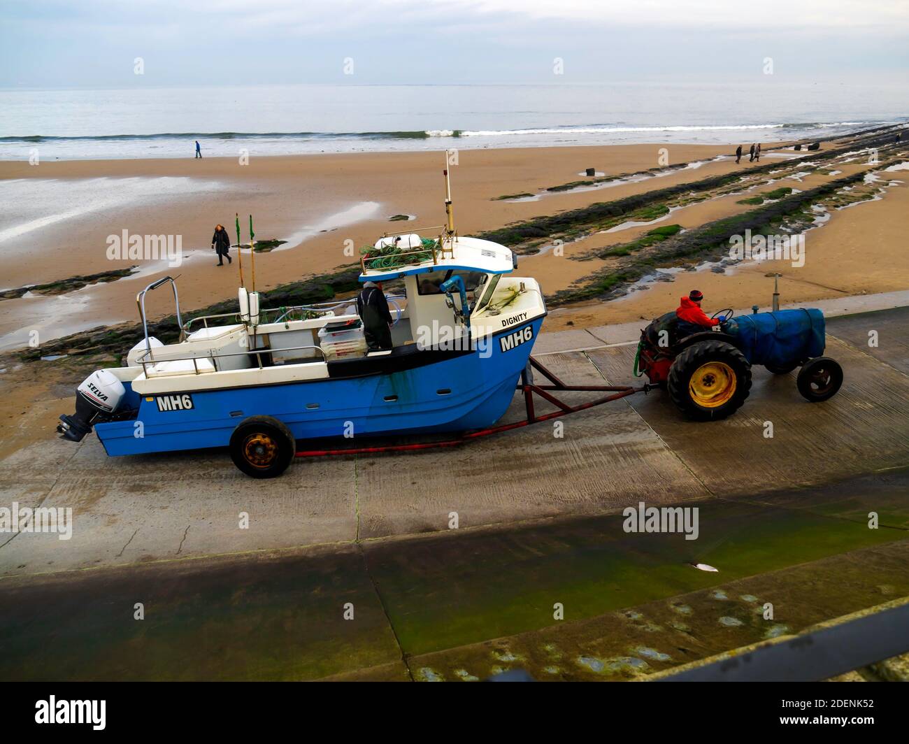 Fisherman driving a tractor hauling his boat MH6 Dignity up the slipway ...