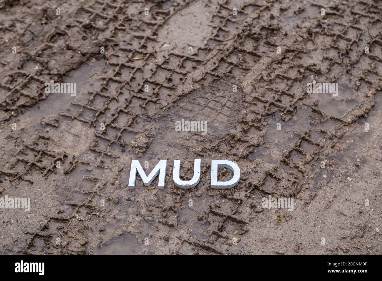 the word mud laid with silver metal letters on wet dirt surface Stock ...