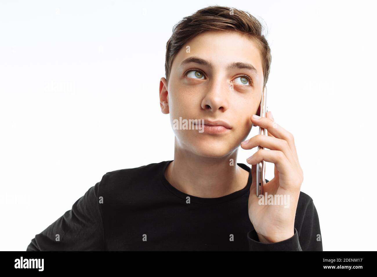 Portrait of an emotional teenager, talking on the phone, in a black t ...