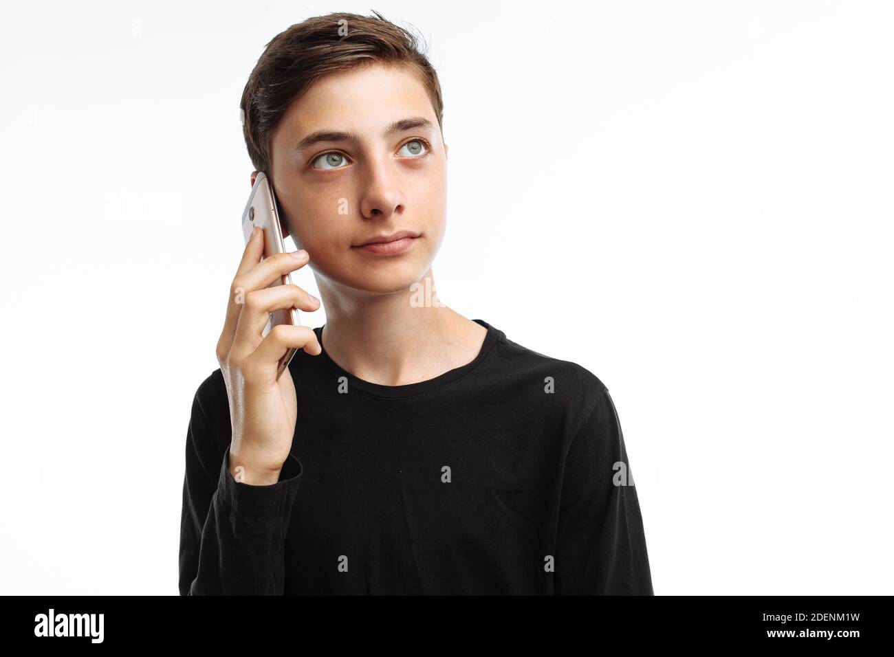 Portrait of an emotional teenager, talking on the phone, in a black t ...