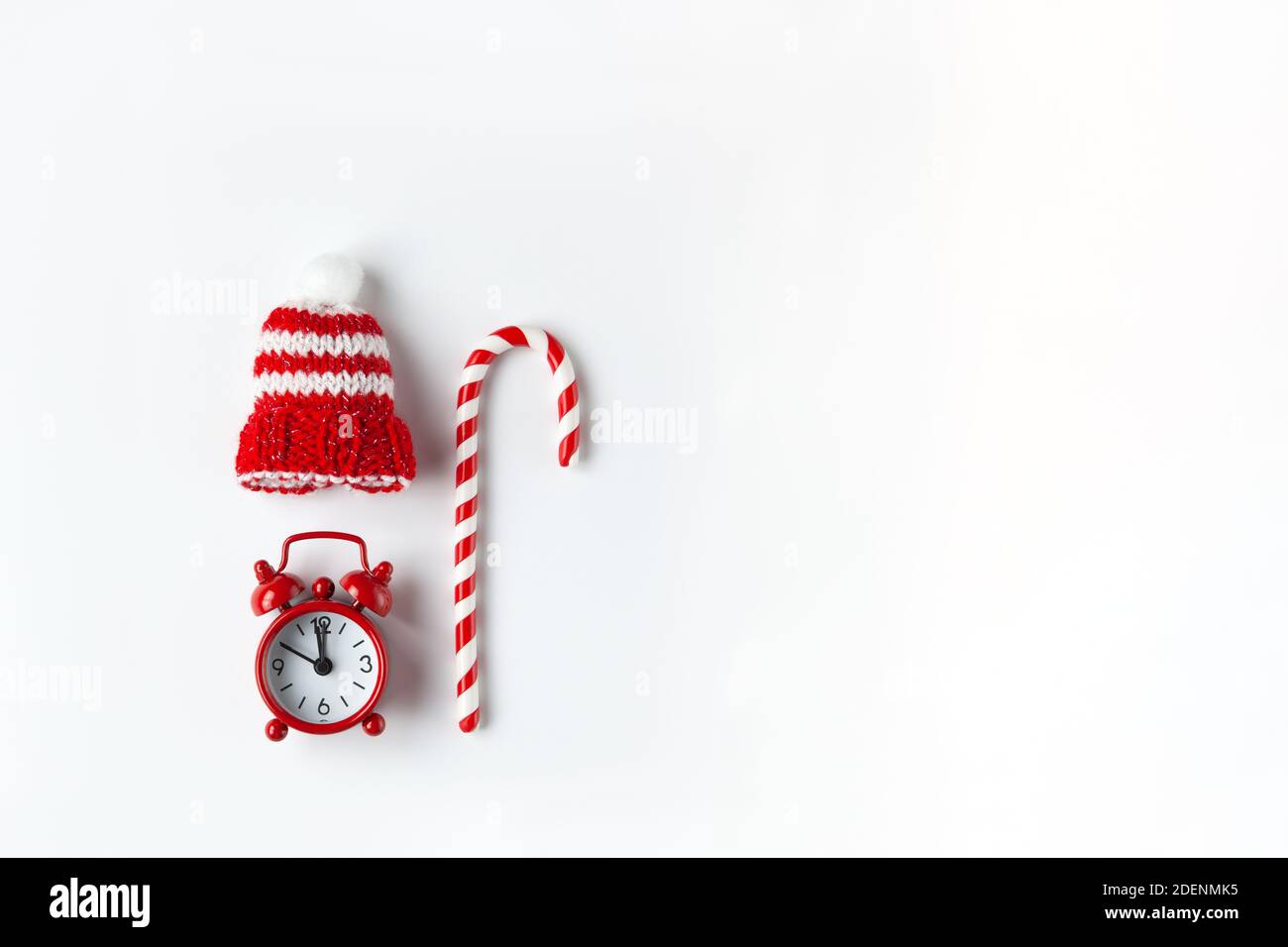 Christmas composition, cane candy, small analog clock, striped hat on ...