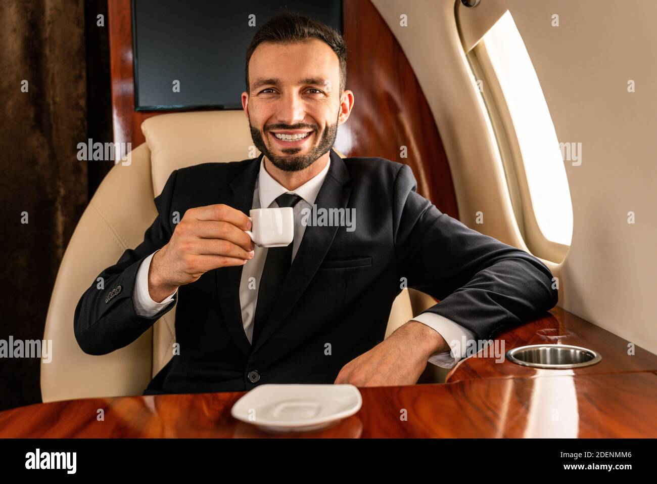 Handsome businessman wearing elegant suit flying on exclusive private ...