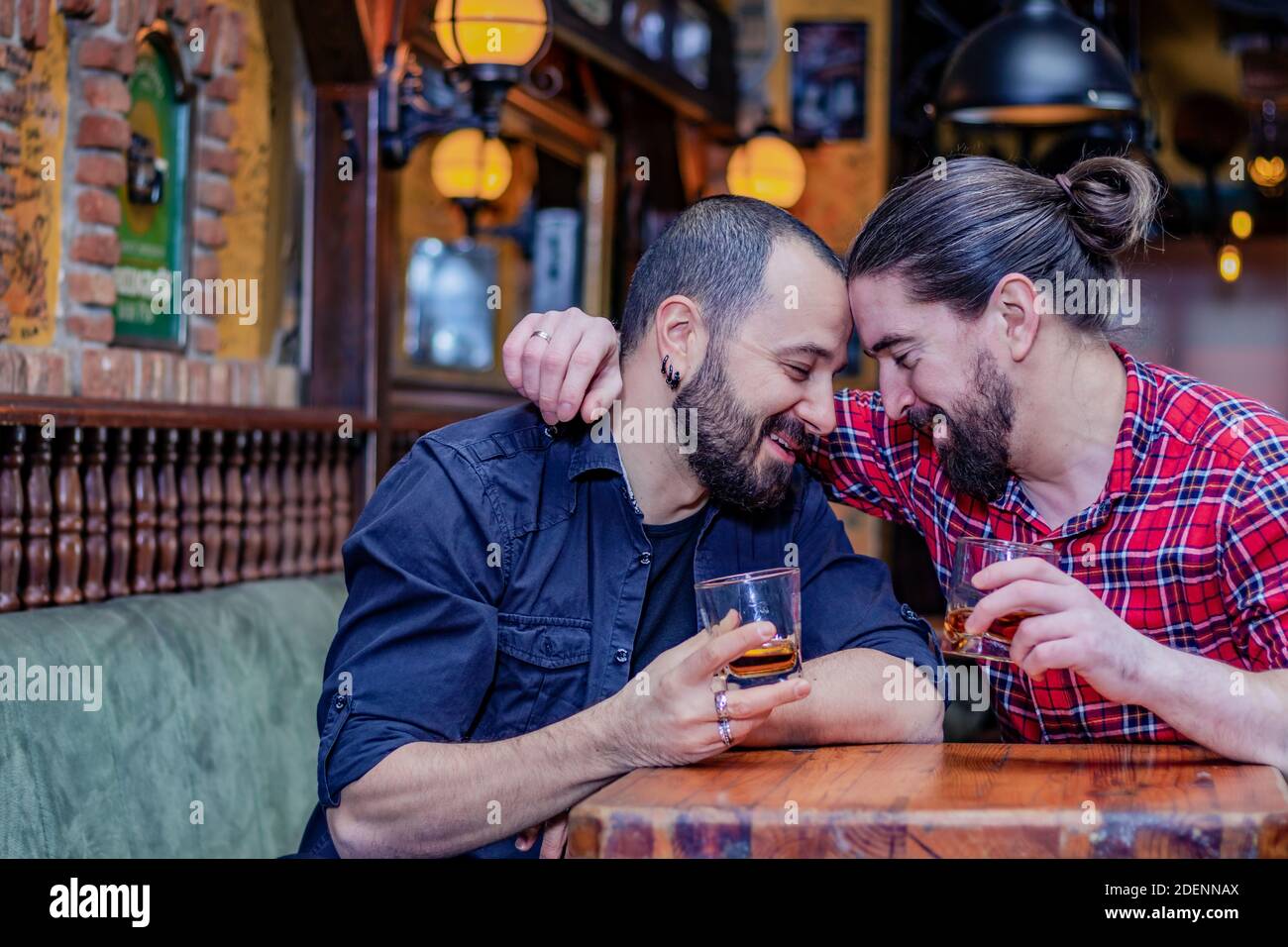 Two male friends drinking whiskey together at the pub. They are drunk ...