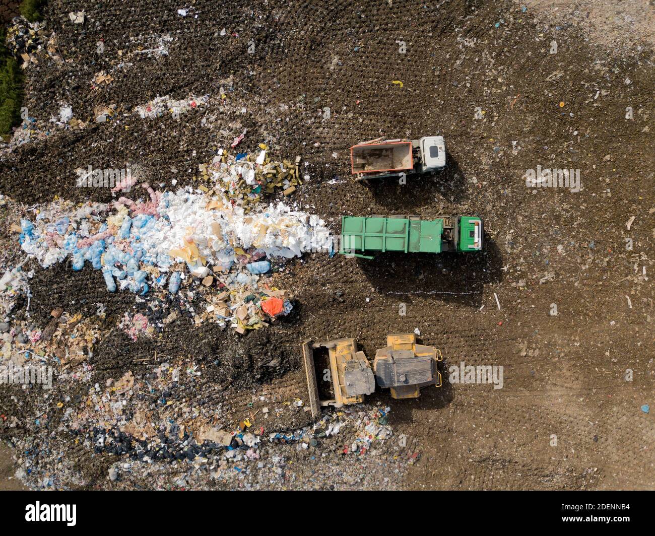 Top view of dump with different waste. Yellow tractor. Green garbage ...