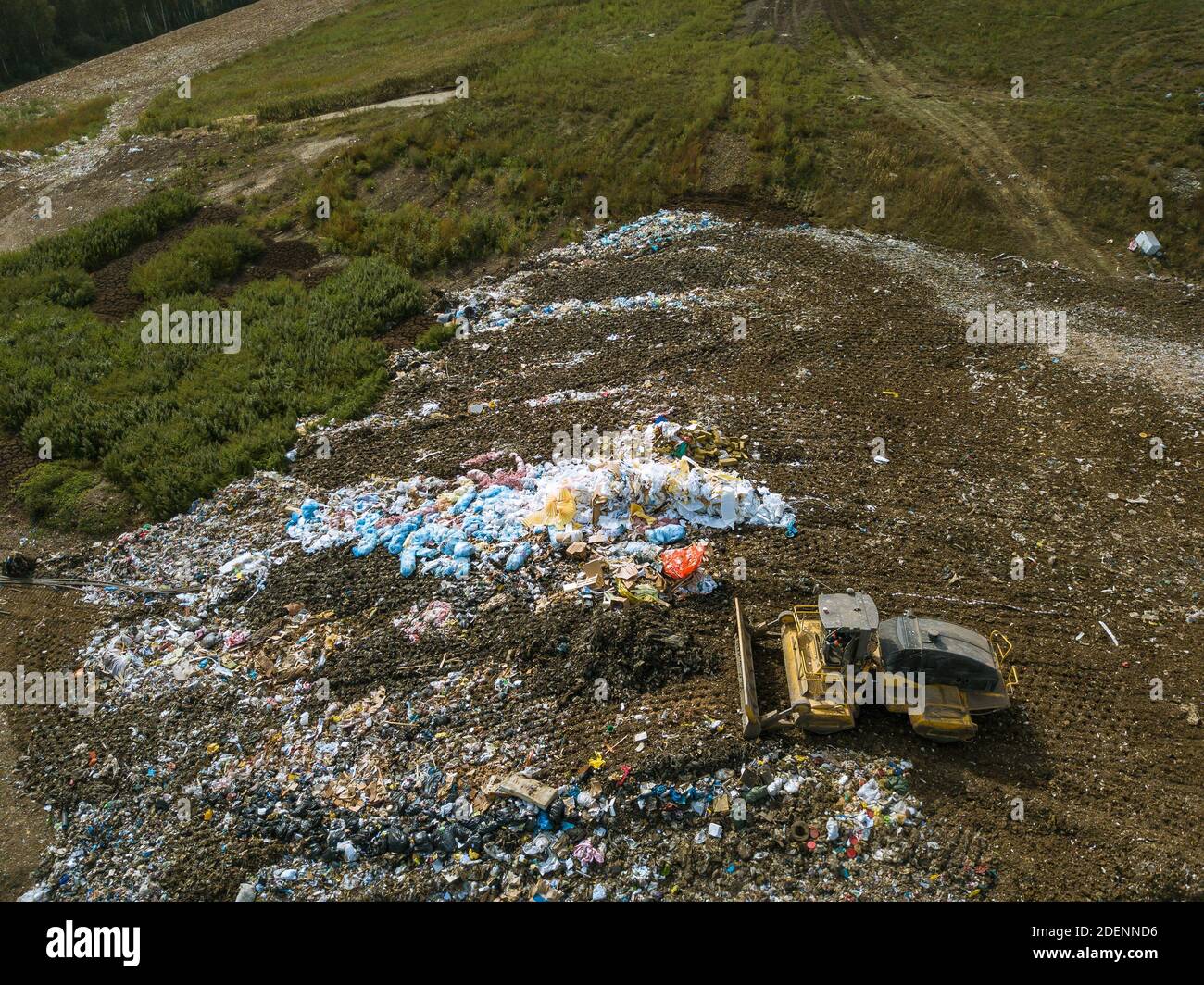 Yellow tractor works on landfill. Waste sorting. Drone view of dump ...