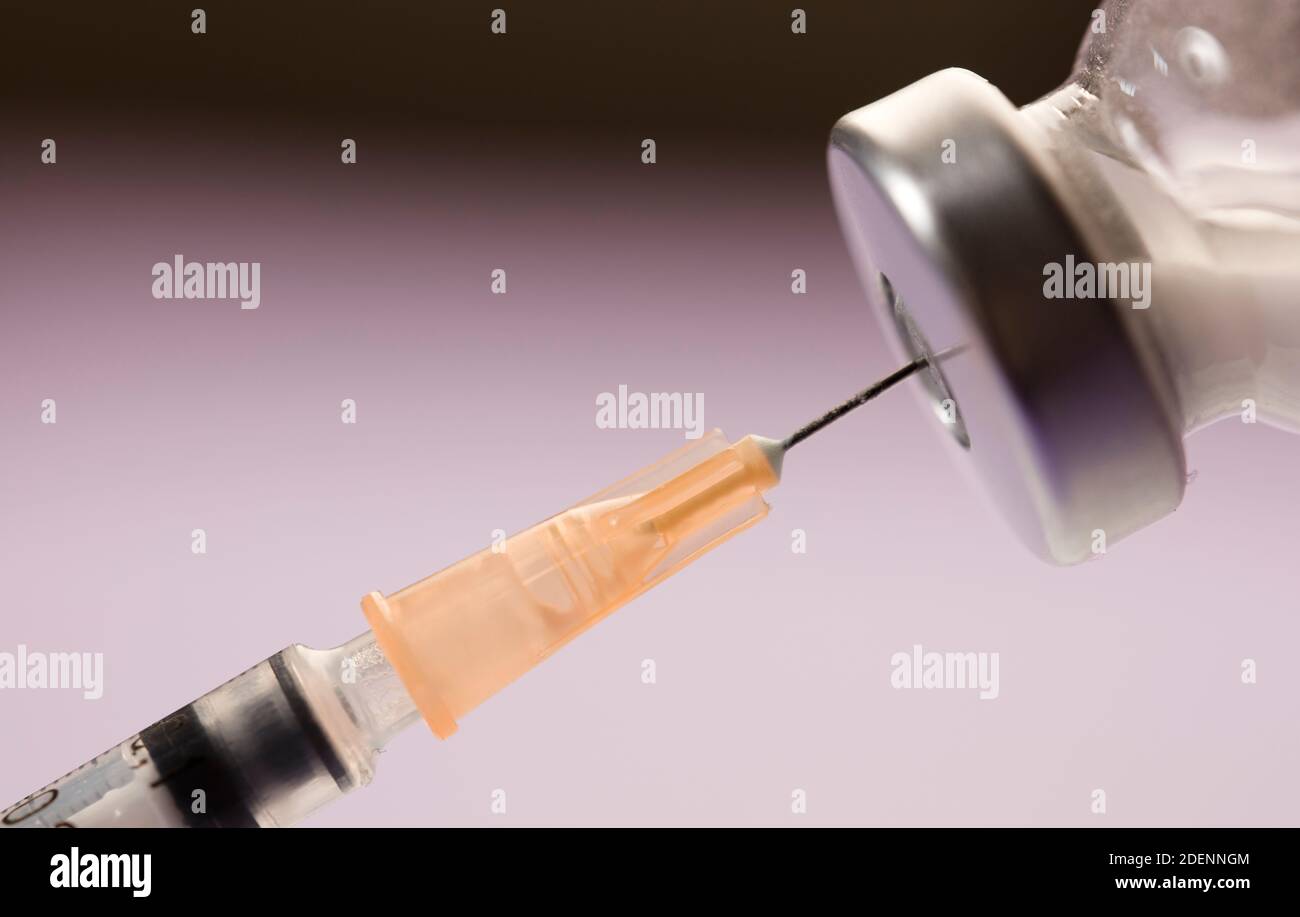 medical syringe cannula with vaccine vial, lilac background. macro ...