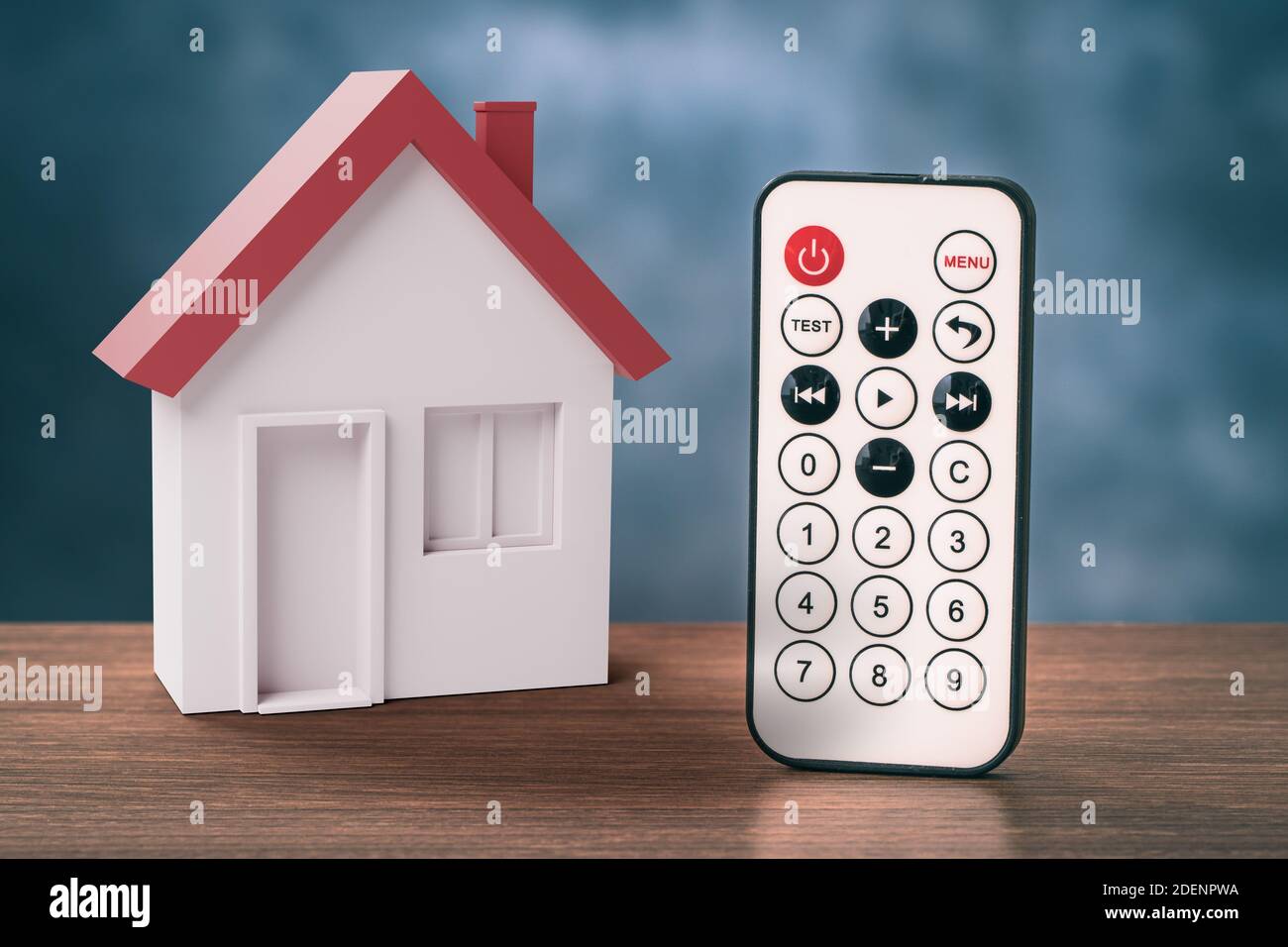 Remote control device and house model on wooden desk. Smart house ...
