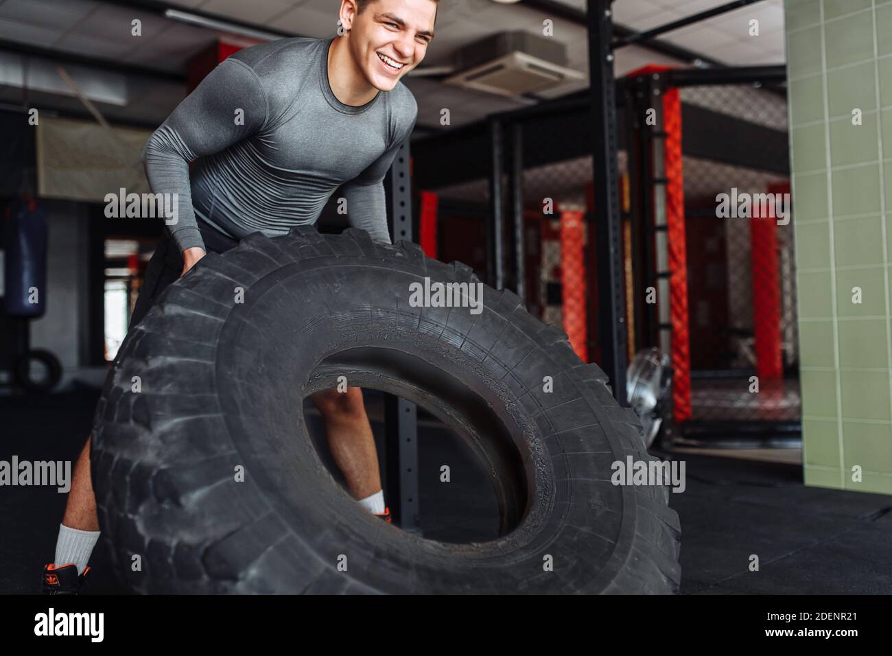 A man raises a big wheel in the gym Stock Photo - Alamy