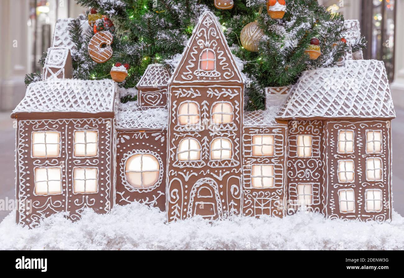 Gingerbread houses with glowing windows near the Christmas tree ...