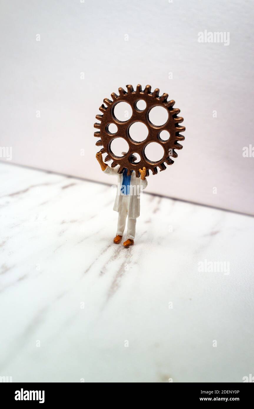 Miniature businessman carrying giant gear symbolizing being creative ...