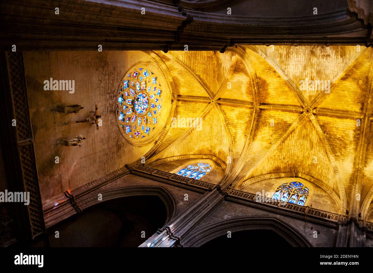 Rose window, golden ceiling and pointed arches of Seville Cathedral in ...