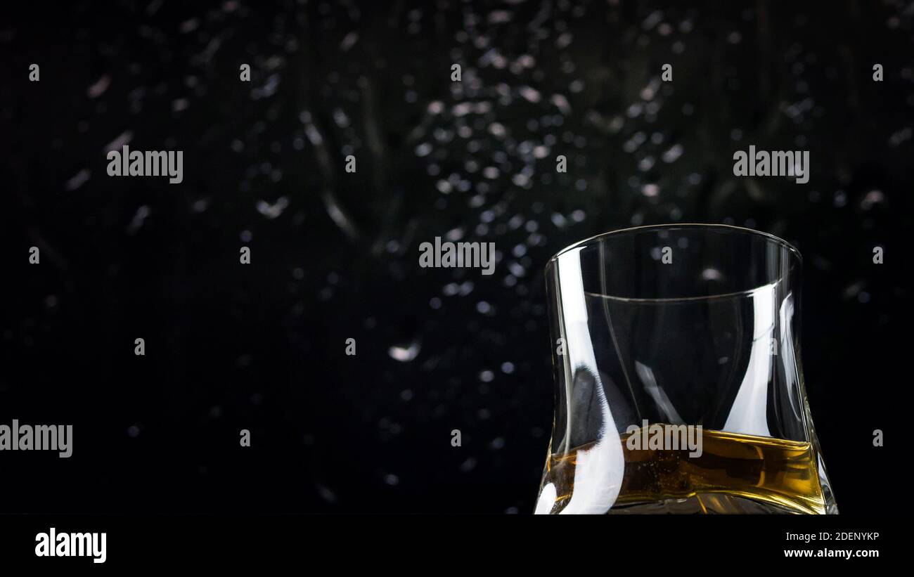 Whiskey against the background of the rain outside the window ...