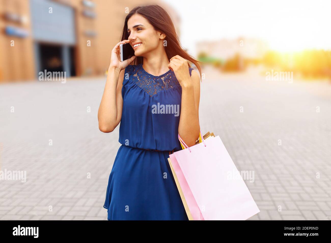 Woman with phone and shopping in hand, shopping online Stock Photo - Alamy