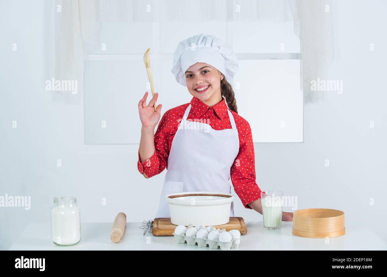 making cake by recipe. time to eat. happy child cooking in kitchen ...