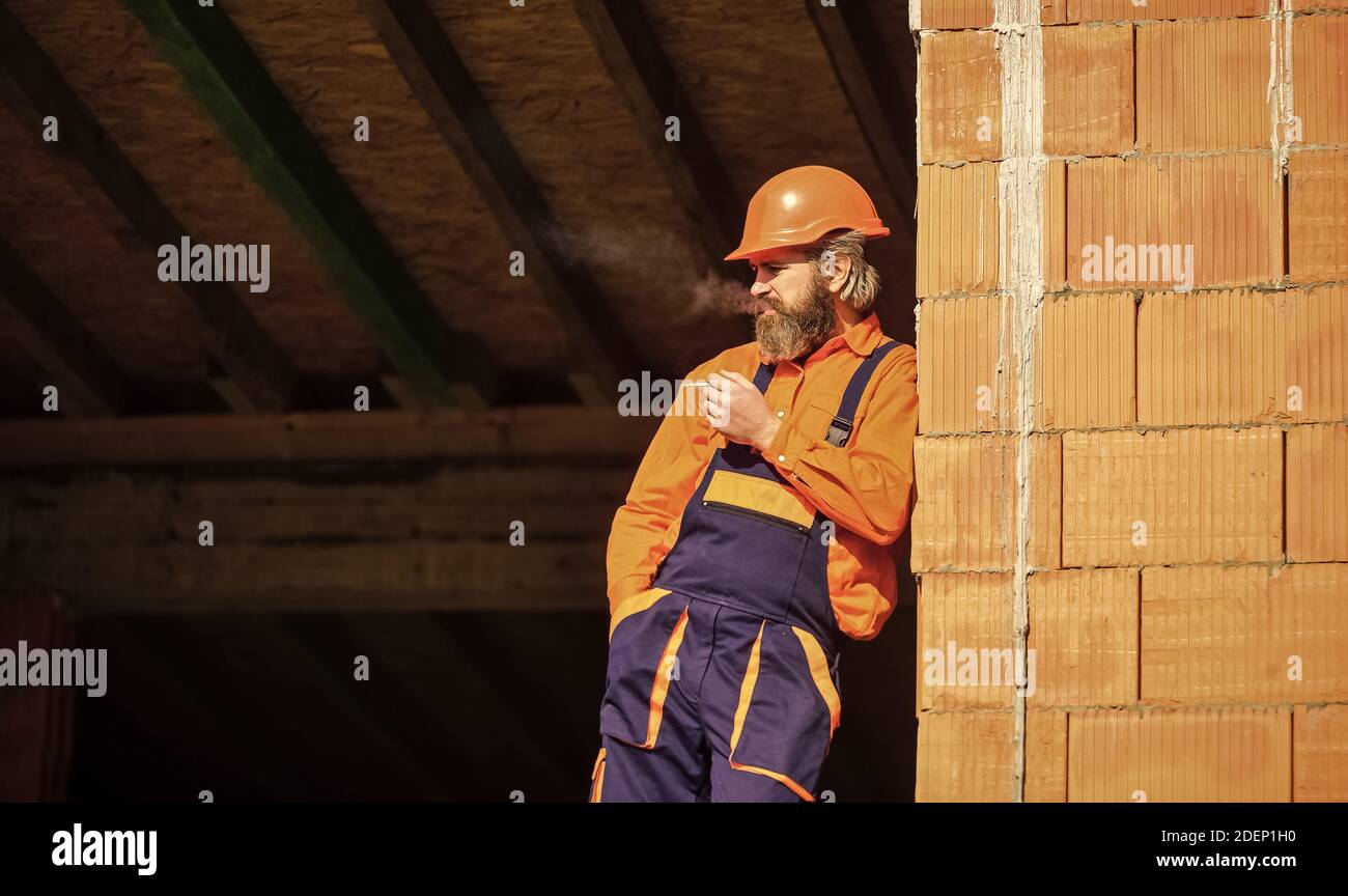 construction worker smoking cigarette. building is under construction ...