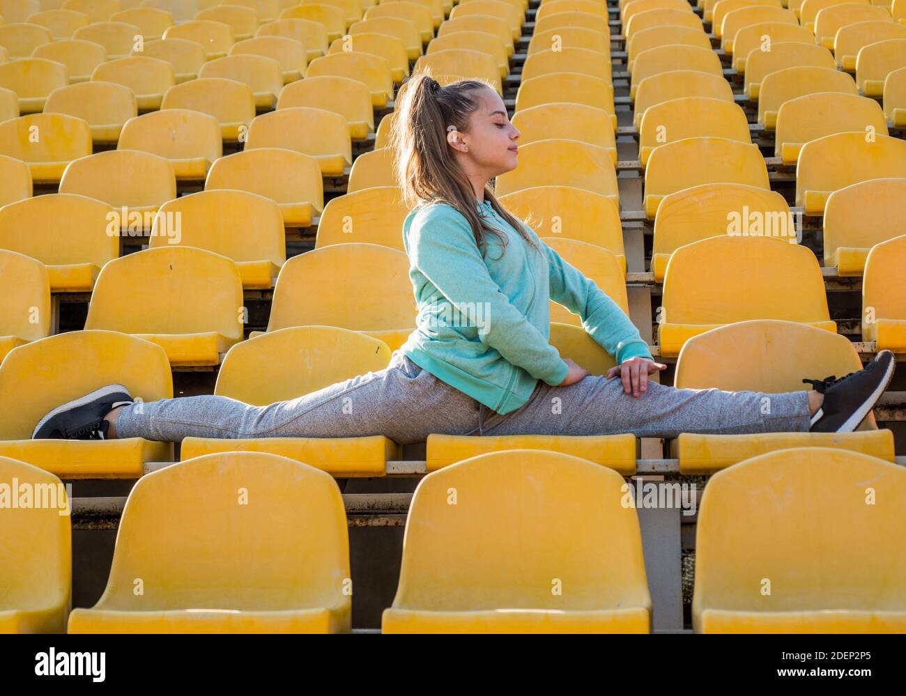 healthy child girl training fitness on stadium running track, split ...