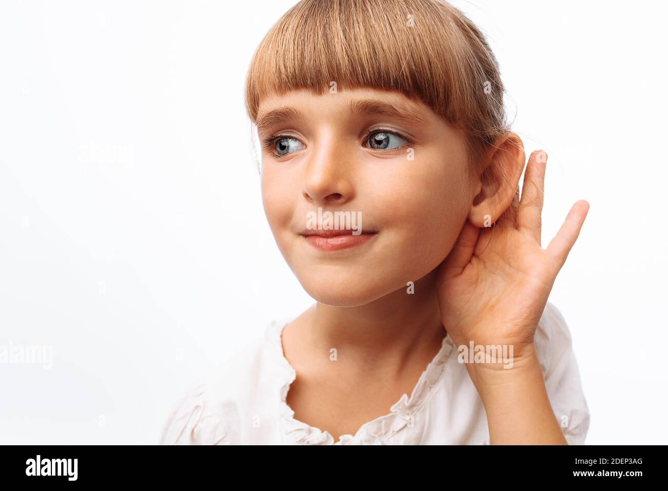Baby girl eavesdropping or listening, in Studio on white background ...