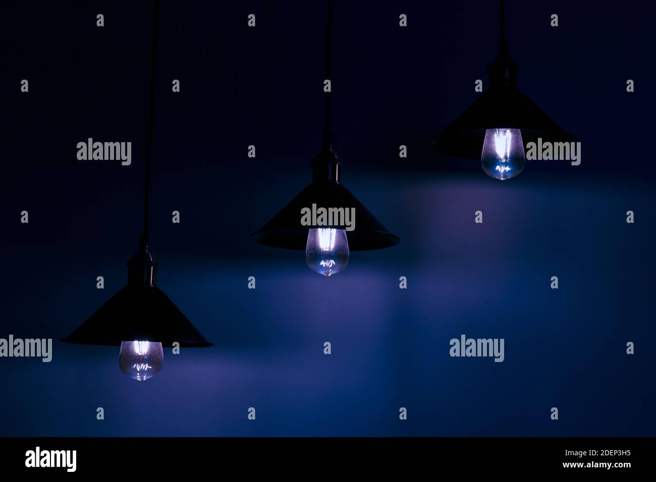 Three lamps with vintage incandescent bulbs in blue light Stock Photo ...
