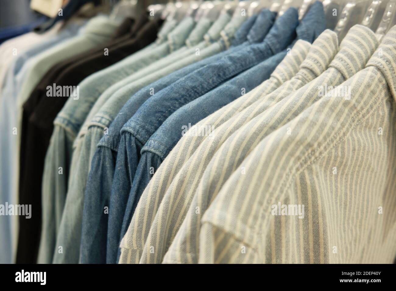 Different casual men shirts hang on hanger racks at store Stock Photo ...