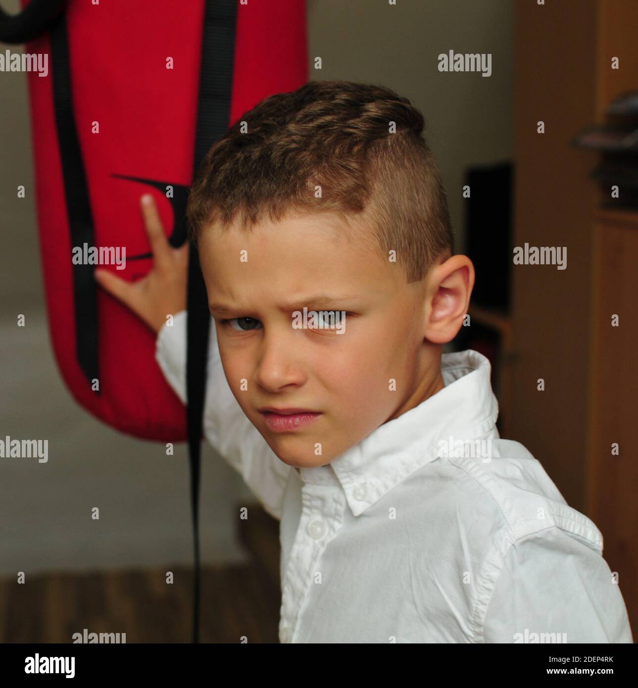 European child from the side looks into the camera with punch bag Stock ...