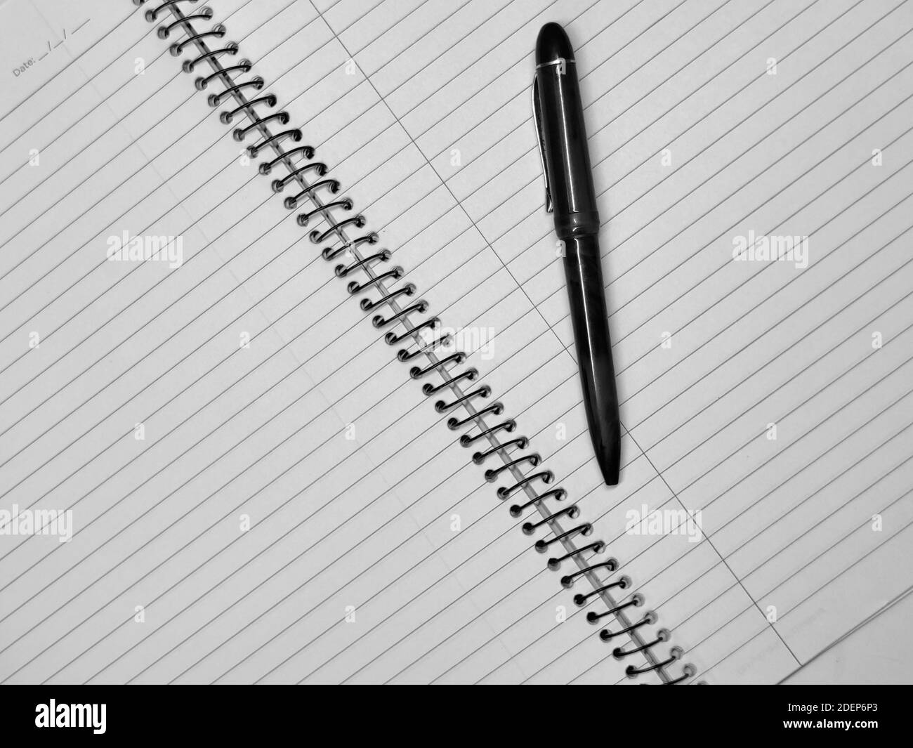 A grayscale top view of an opened notebook and pen Stock Photo - Alamy