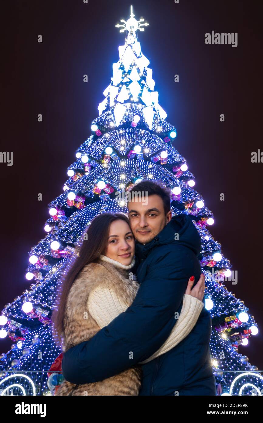 Couple hugging at the Christmas tree Stock Photo - Alamy