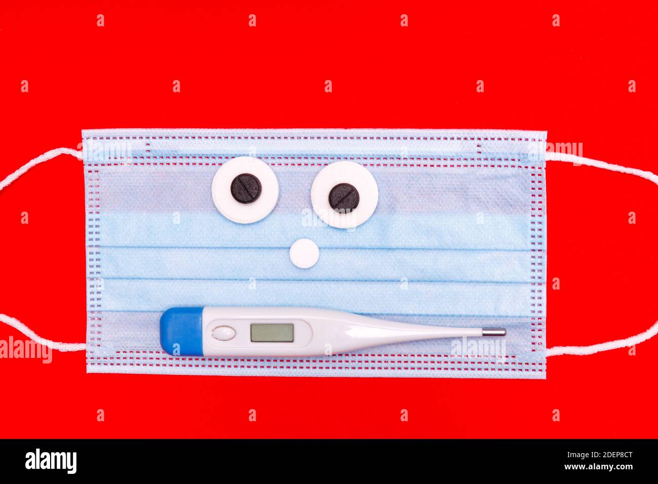 medical mask with a face of tablets and a thermometer Stock Photo - Alamy