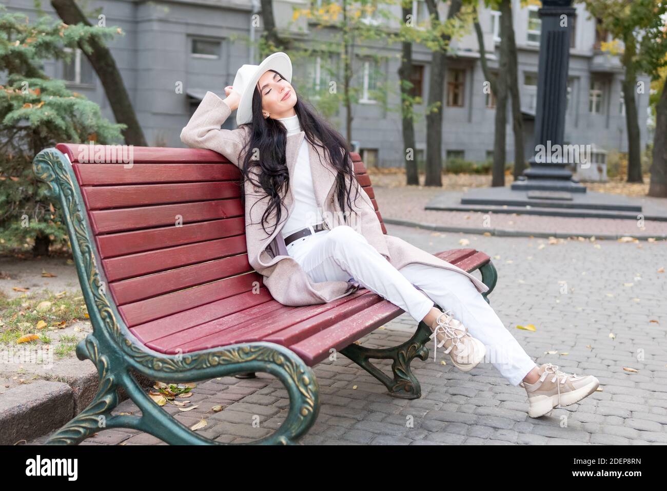 woman sat down to rest on bench Stock Photo - Alamy