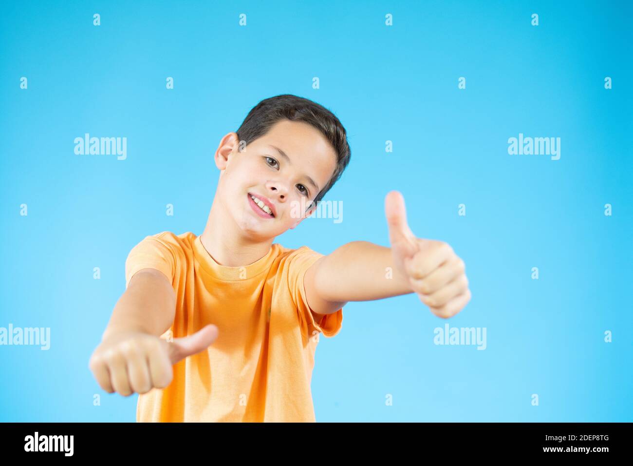 Beautiful boy showing okay gesture in sign language on blue background ...