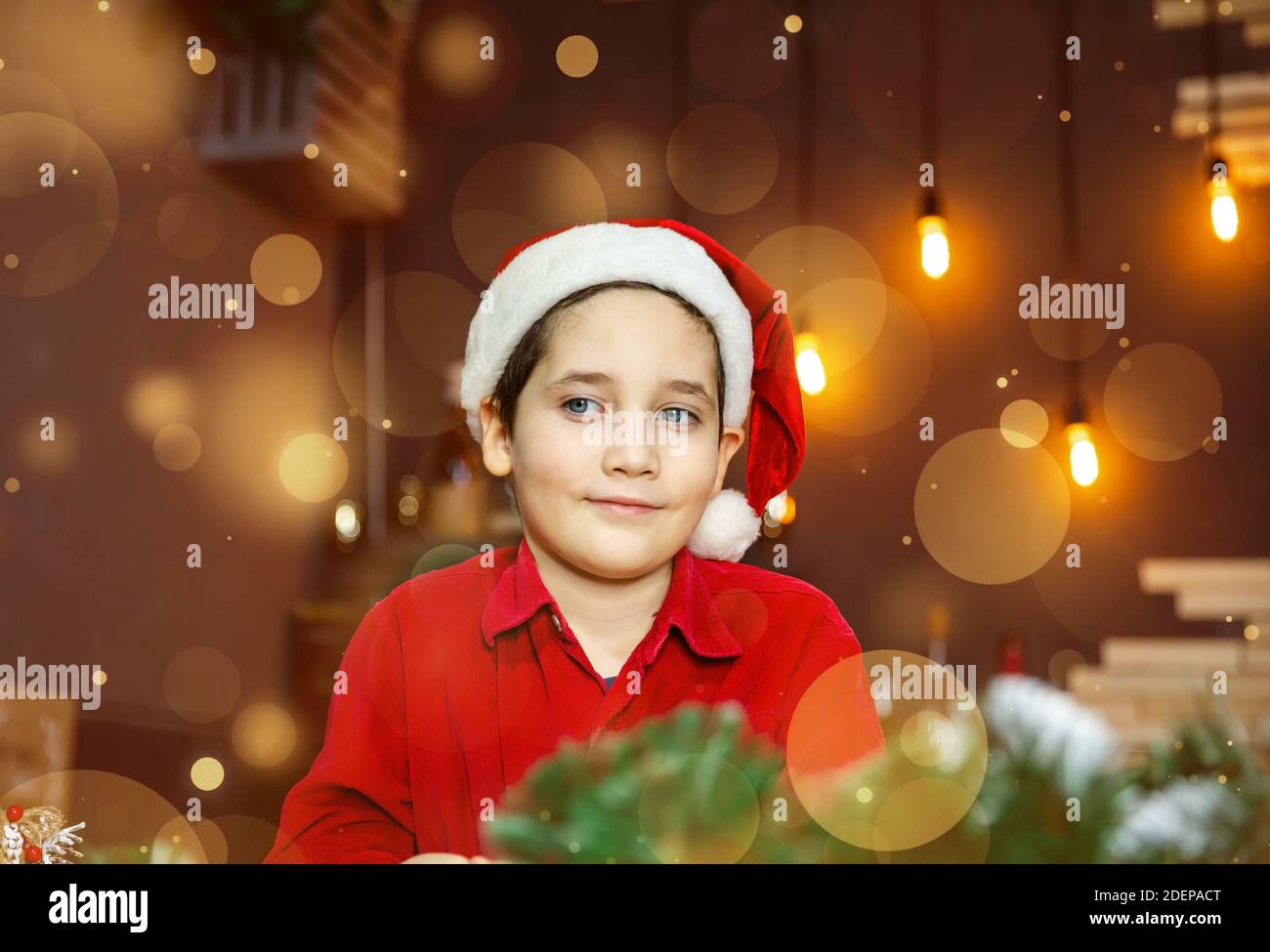 Beautiful cute boy in Santa Claus cap on blurred golden background ...