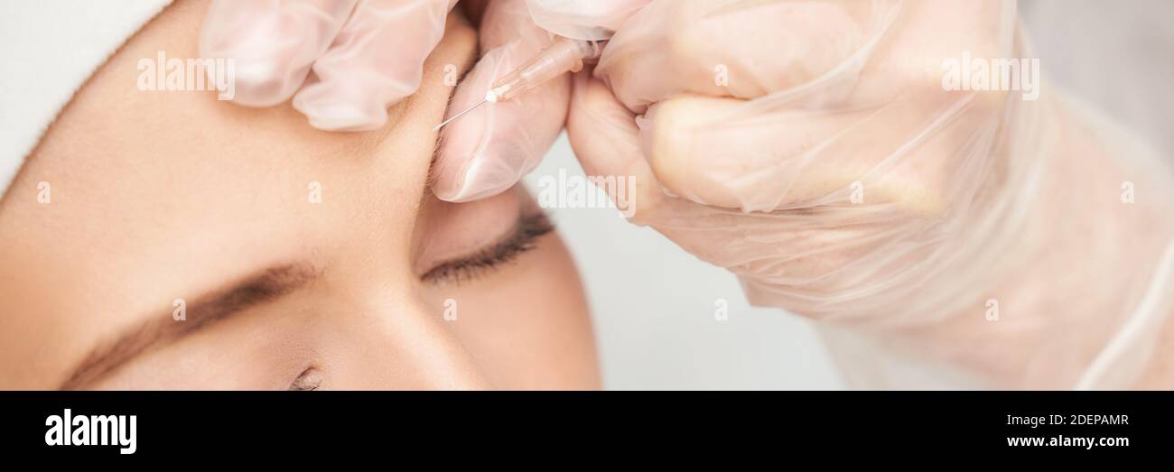Forehead injection at spa salon. Doctor hands. Pretty female patient ...