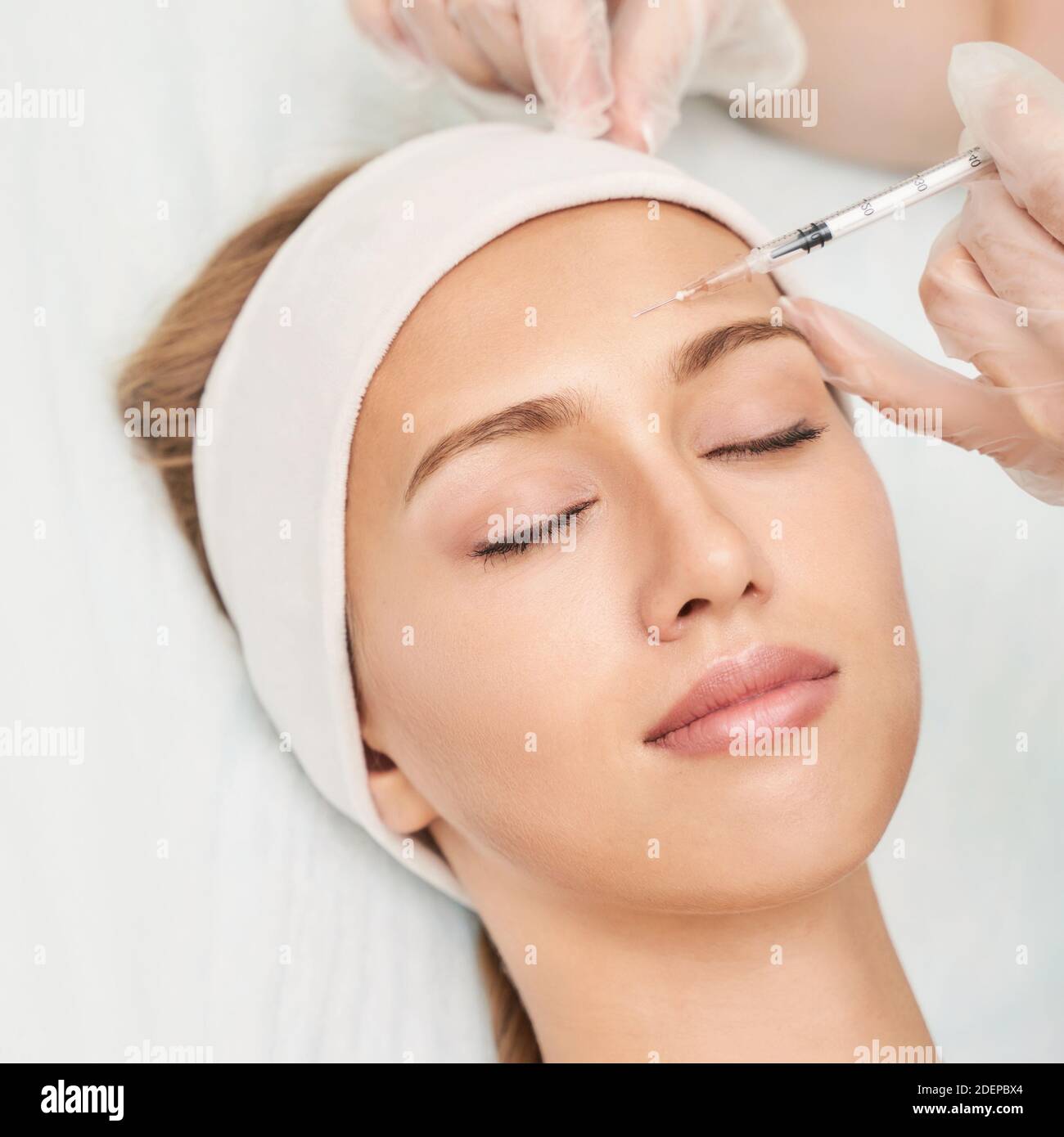 Forehead injection at spa salon. Doctor hands. Pretty female patient ...