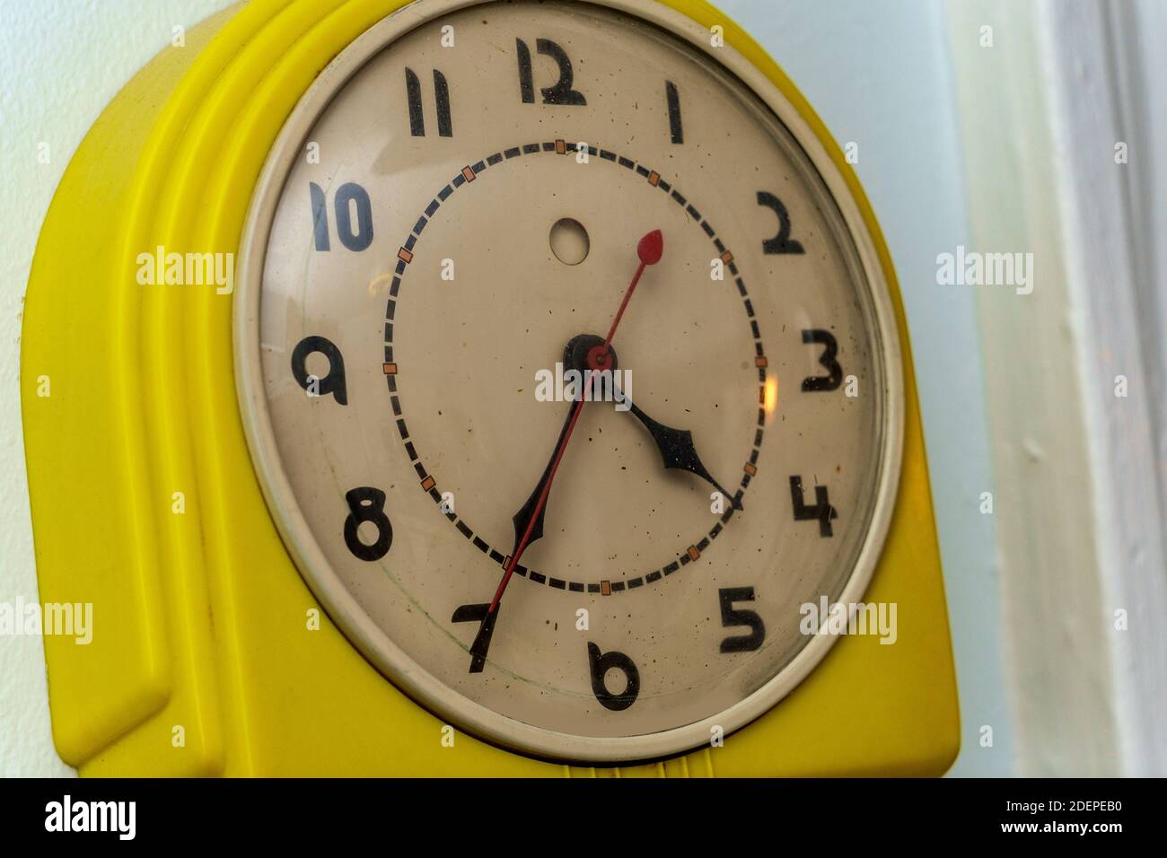Old dirty antique yellow electric clock hanging on wall Stock Photo - Alamy