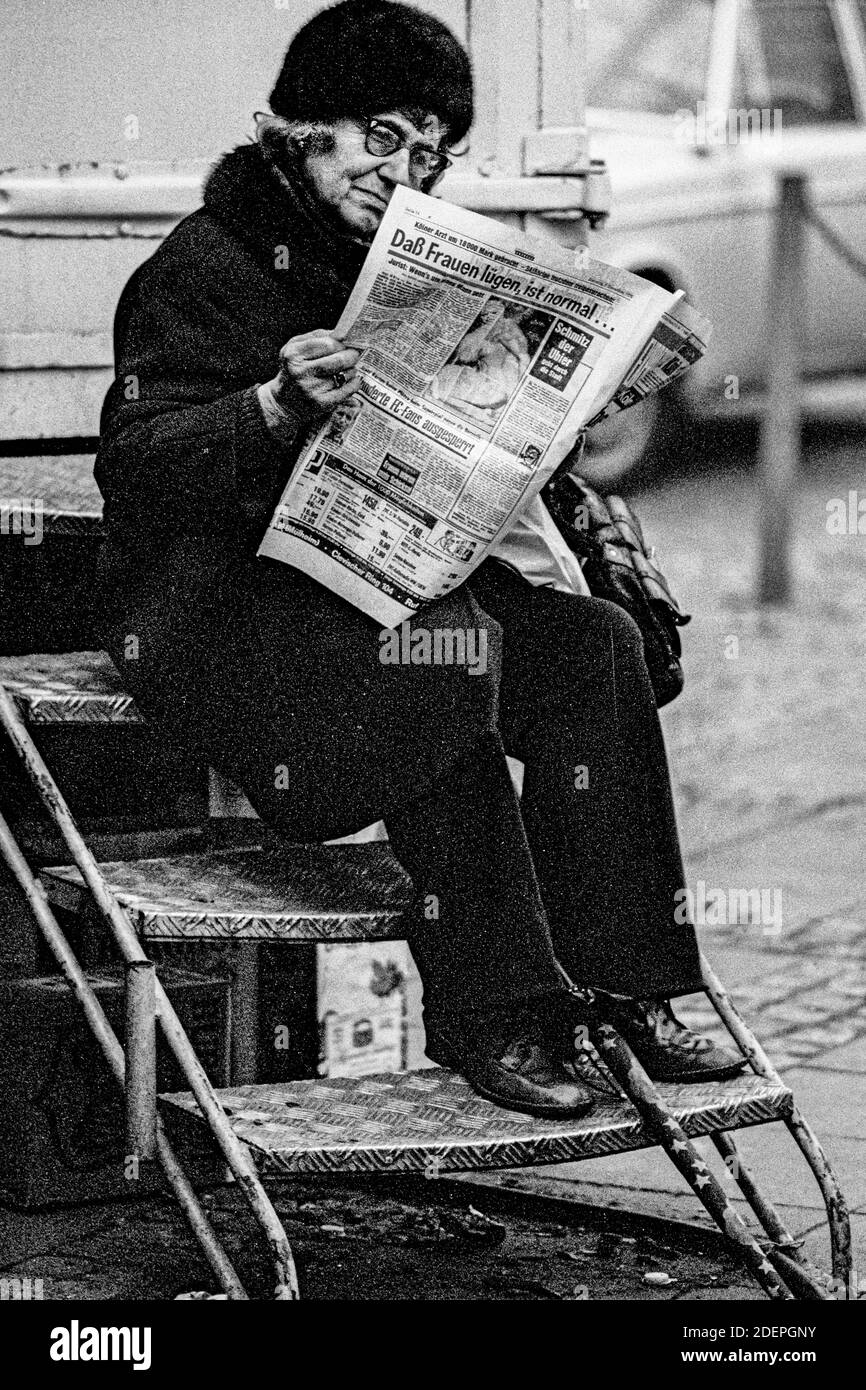 Woman reading Headline in German Newspaper spelling: It is normal for ...