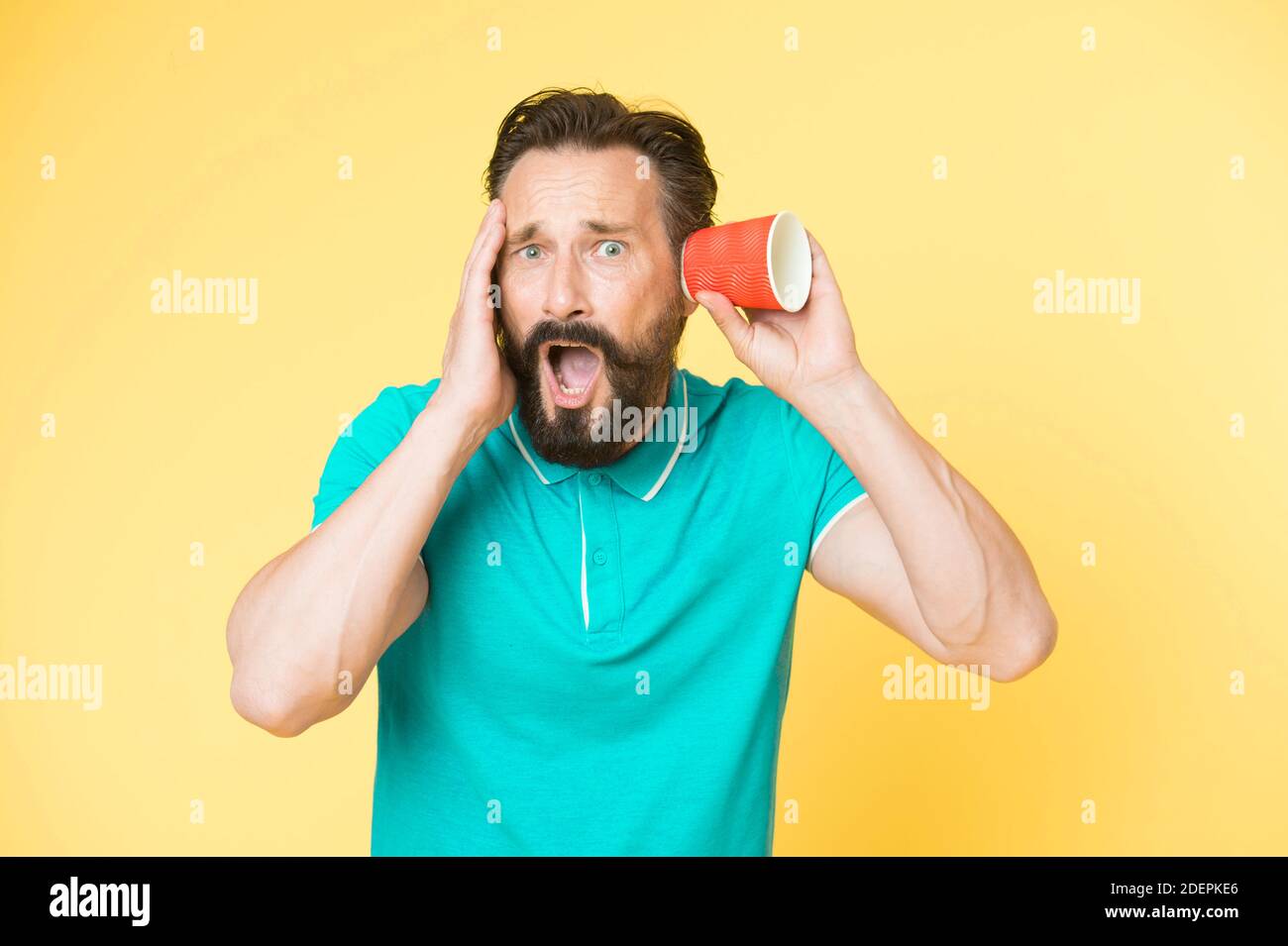 Shocking rumors. Man bearded mature guy eavesdrops with cup yellow ...