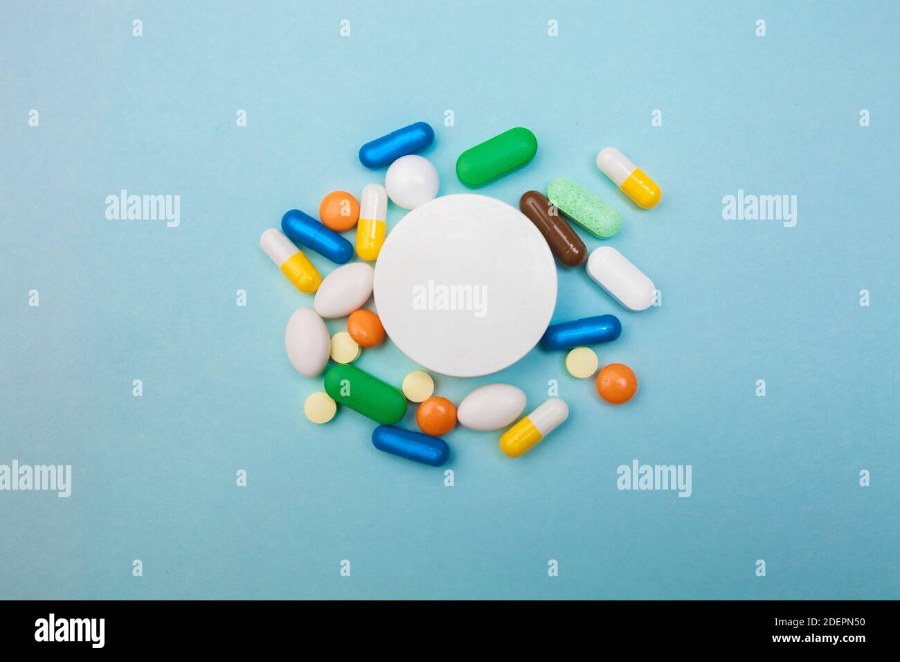 Multi-colored tablets and capsules, white bottle for tablets ...