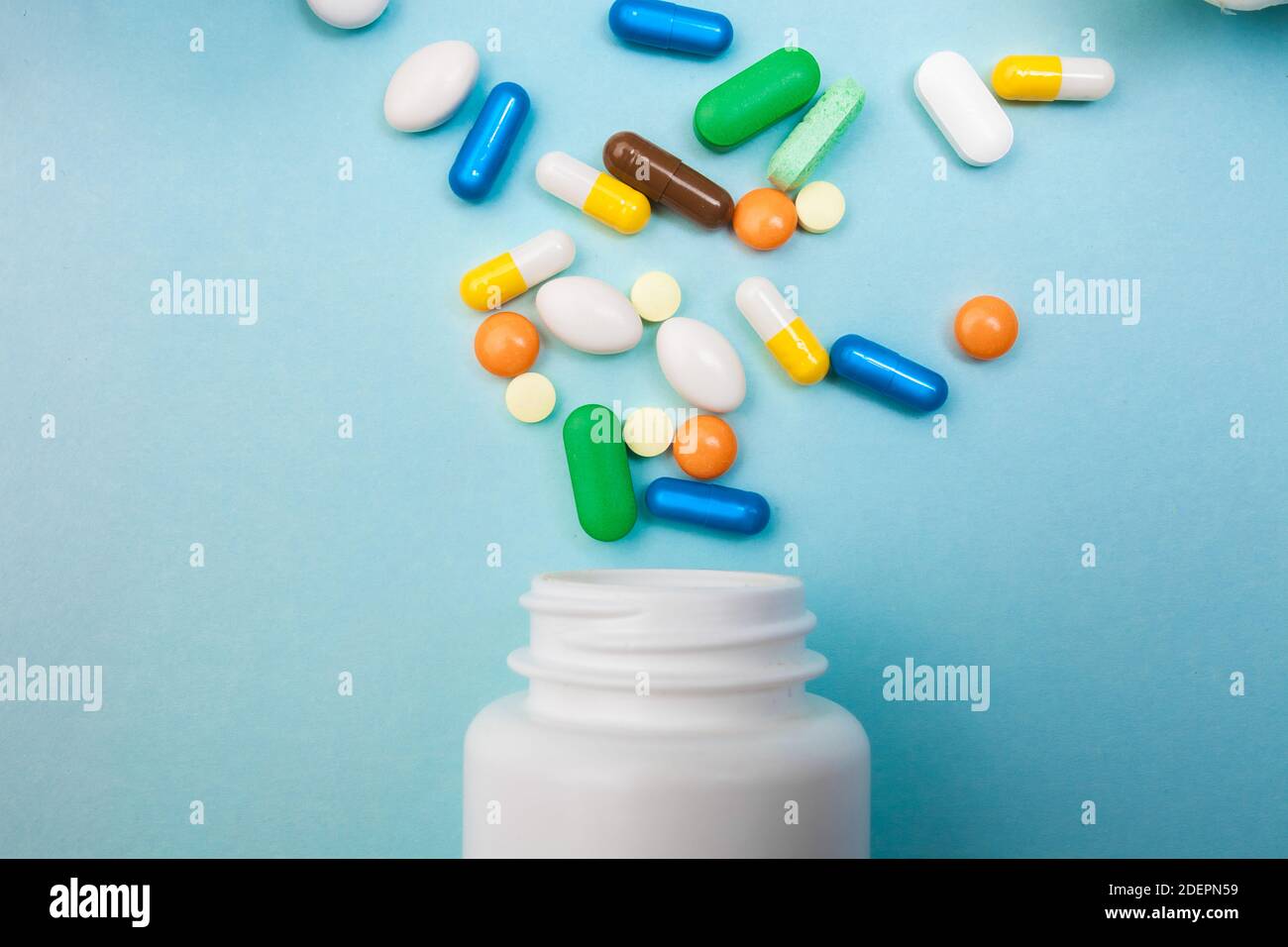 Multi-colored tablets and capsules, white bottle for tablets ...